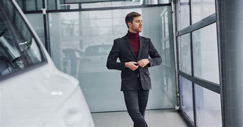 고급 정장과 정장을 입은 젊은 사업가가 차 근처 실내에 있습니다 사진 Unsplash의 양복 이미지