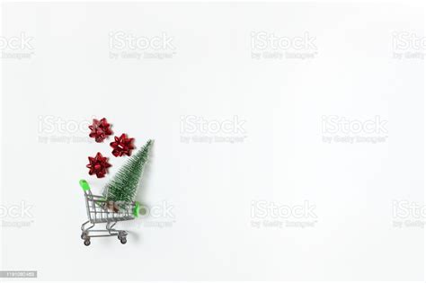 크리스마스 눈 흰색 배경에 장난감 쇼핑 카트에 선물에 대 한 전나무와 빨간 활 덮여 복사 공간 새해 판매 온라인 쇼핑 개념 수평 평평한 평신도 최소한의 스타일 맨 위 보기