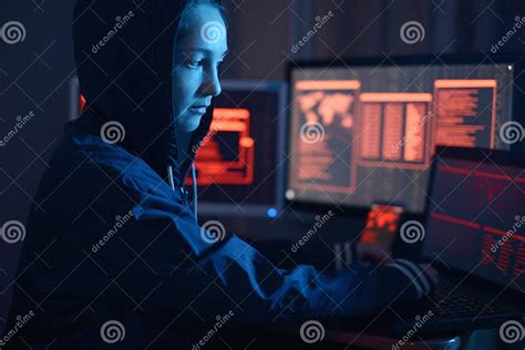 Girl Hacker In A Hood Typing Program Code While Committing A Cybercrime Hacking A System On The