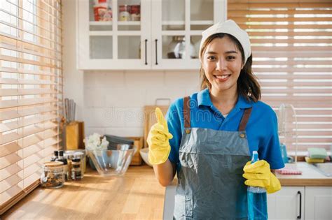 Hygiene Conscious Woman In Apron And Glove Ready For Housework Holding