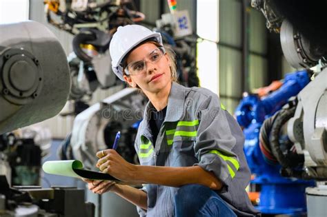 female engineer worker working with robotic machine automation stock