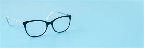 밝은 파란색 테이블 배경에 짙은 검은색 플라스틱 프레임이 있는 안경입니다 파스텔 색상 와이드 배너 근접 촬영 텍스트를 위한 빈