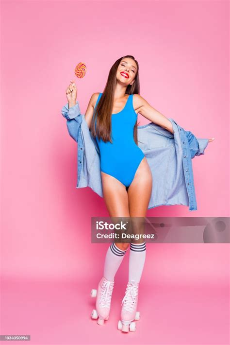 꽤 밝은 빛나는 밝은 귀여운 매력적인 매력적인 거리 스타일 여자 먹는 하드 캐 러 멜 절연 배경 좋은 느낌의 전체 길이 크기 시체 사진 초상화 롤러 스케이트에 대한 스톡