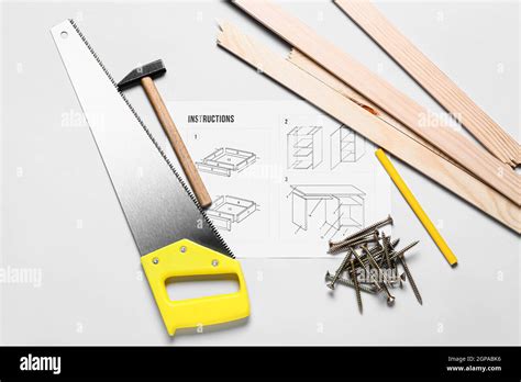 Furniture Assembling Instructions Wooden Planks And Tools On White