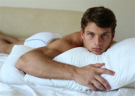 Naked Shirtless Man In Blue Jeans Lying On His Bed At Home Looking