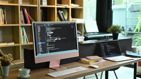 Premium Photo | Computer pc and laptop with programming code on screens at software development ...