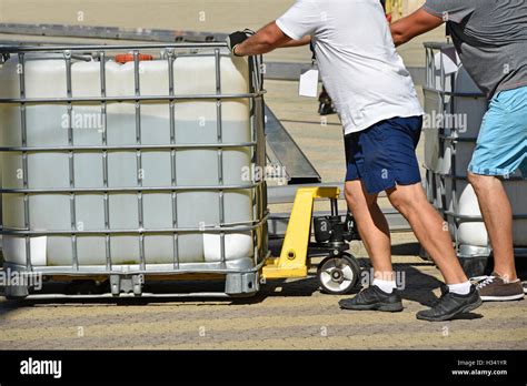 Men Are Moving A Large Water Container With A Hydraulic Forklift Stock Photo Alamy