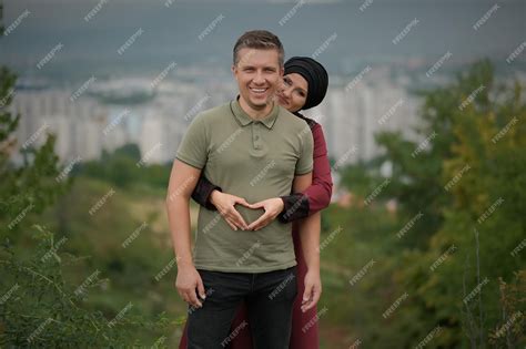 Счастливая мусульманская пара молодая жена в хиджабе обнимает своего ...