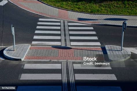 교차로에서 방향으로 나뉘어진 차선 횡단에는 보행자를위한 안전 섬이 있습니다 장님을위한 간판 거리 교차로의 포괄적 인 교통 표시 전문 지식 운송 연구 건널목에 대한 스톡 사진