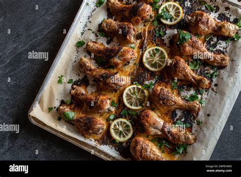 Oven Baked Chicken Drumsticks On A Baking Tray Isolated On Dark