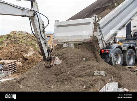 Excavator And Truck Unloading The Delivery Construction Site And Construction Industry Stock