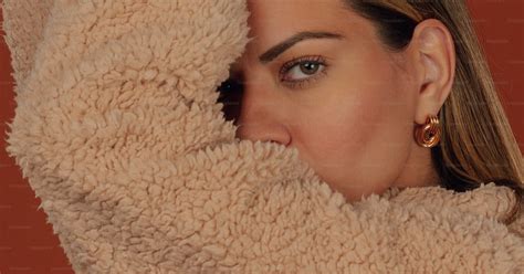 보송보송한 코트를 입은 여자가 손으로 얼굴을 가리고 있다 사진 Unsplash의 초상 이미지