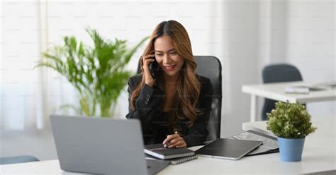 성공적이고 매력적인 아시아 여성 매니저가 비즈니스 파트너와 전화를 걸고 있다 비즈니스 여자가 전화로 이야기하고 있다 사진