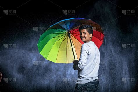 手里拿着伞的印度男孩