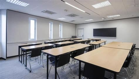 Empty Classroom With Light Beige Tables And Black Chairs Stock