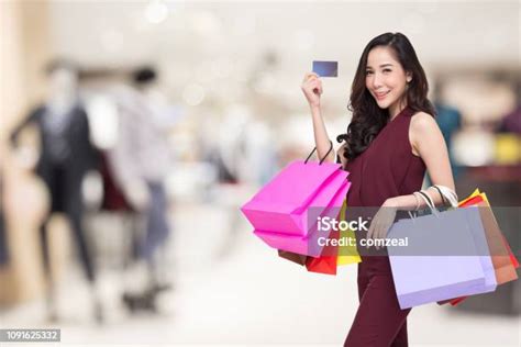 쇼핑백과 쇼핑 개념 아시아 모델에 대 한 년 판매 프로 모션 허가 중반 흐리게 몰 배경 년 끝 판매와 신용 카드를 들고 빨간 드레스에 행복 한 여자의 초상화 캐시백 금융에