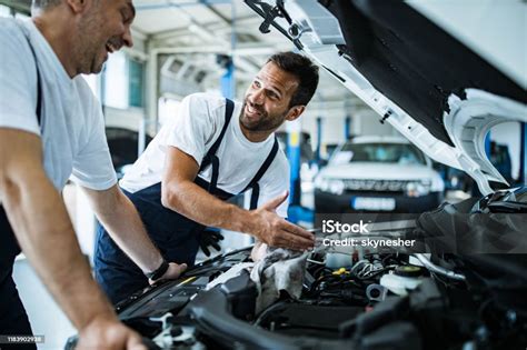 워크샵에서 자동차 엔진에서 작업하는 동안 말하는 행복한 자동차 역학 기계공에 대한 스톡 사진 및 기타 이미지 기계공 2명 검사 보기 Istock