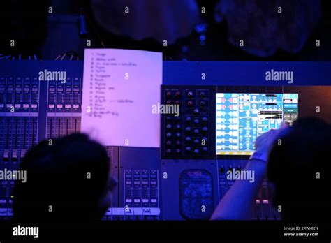 Sound Engineers Working With Mixing Console Regulating Level Of Sound During Concert In A Hall