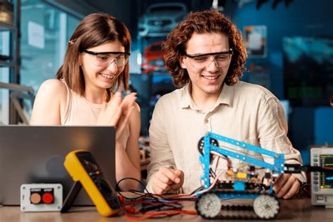 Free Photo Young Man And Woman In Protective Glasses Doing Experiments In Robotics In A Laboratory