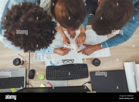 Team Of Three Young Architects Are Working On A New Project And Communicating While Analyzing