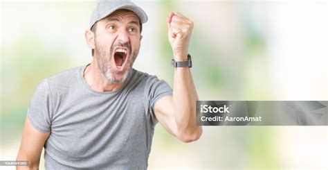 잘생긴 중 년 노인의 수석 남자 이상의 스포츠 모자를 입고 분노 하 고 좌절 하 고 분노와 함께 외치는 동안 분노 주먹 양육 화