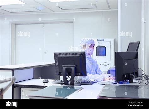 Female Factory Worker Using Computer In Flexible Electronics Factory Clean Room Stock Photo Alamy