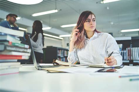 매력적인 전문 여성 기자 새 문서에 대 한 창의적인 아이디어에 대해 생각 하 고 동료 배경에서 서로 통신 하는 동안 메모장에 일반적인 세부 정보를 작성 숙고 가사 집안일에