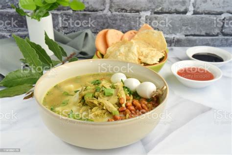 Bubur Ayam 인도네시아 쌀 콘지 또는 죽과 잘게 썬 닭고기 파 샐러리 튀긴 콩 삶은 메추라기 달걀 노란 닭 육수 및 Kerupuk 또는 크래커 0명에 대한 스톡 사진