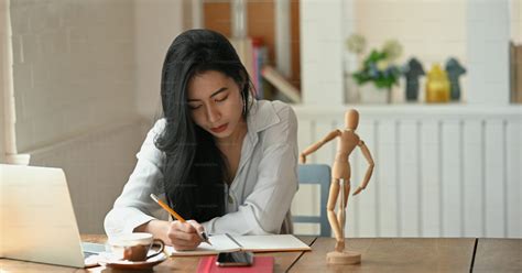 아시아 여성은 홈 오피스 작업 공간에서 노트북 종이에 글을 쓰고 있다 사진 Unsplash의 태국 이미지