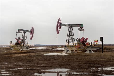빔 펌핑 유닛은 숙제 오일 필드의 일몰입니다 석유 펌프 오일 장비 에너지 산업 기계 펌프가 우물에 설치 된 펌핑 장치 오일 분야의 장비 강철에 대한 스톡 사진 및 기타