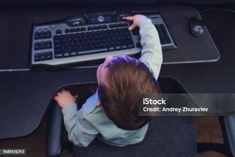 행복한 아기가 모니터 옆의 컴퓨터 키보드에 앉아 있다 집 거실에서 데스크톱 Pc를 들고 웃고 있는 아이 생후 1년 9개월 아이 가정 생활에 대한 스톡 사진 및 기타 이미지