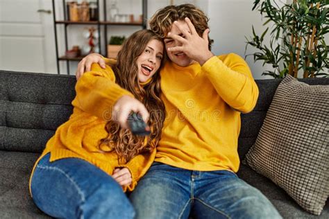 Young Caucasian Couple Watching Movie Hugging Each Other At Home Stock