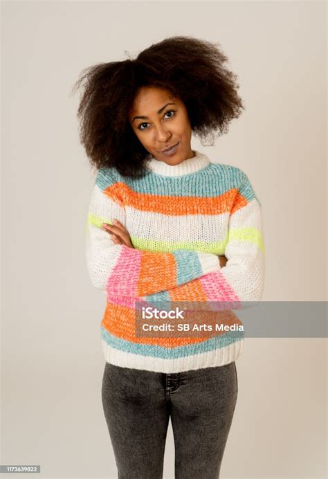 행복 한 젊은 아프리카 계 미국인 여성의 초상화 웃고 중립 배경 위에 고립 된 멀티 컬러 줄무늬 점퍼에서 재미 사람 인간의 긍정적 인 감정과 축하 생활 감정에 대한 스톡