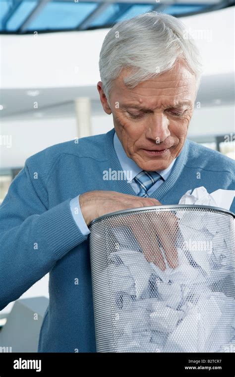 Mature Businessman Looking Into Bin Stock Photo Alamy