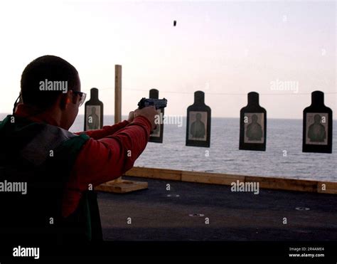 US Navy A Sailor Shoots A 9mm Handgun At A Target During A Live Fire Small Arms Qualification