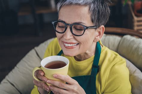 연금 수령자 숙녀 플로리스트 앉다 안락 의자 편하게 하다 냄새 차 향기 입고 있다 녹색 앞치마 일 꽃집 스튜디오 중소기업의 사진