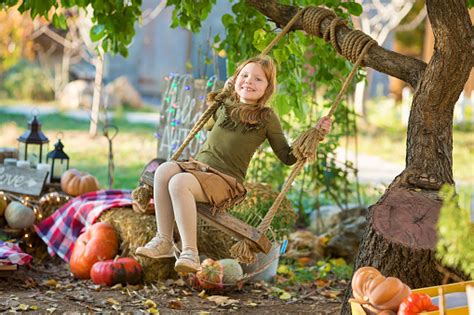 녹색 할로윈 의상 스윙 웨스트 하이랜드 공원에서 할로윈에 대 한 준비에 앉아 무서운 얼굴로 짜증 잭 호박 야외 연주에 재미 있은 여자 아이 아이 10월에 대한 스톡 사진 및