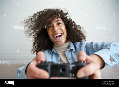 Excited African Girl Gamer Holding Joystick Controller Playing Video