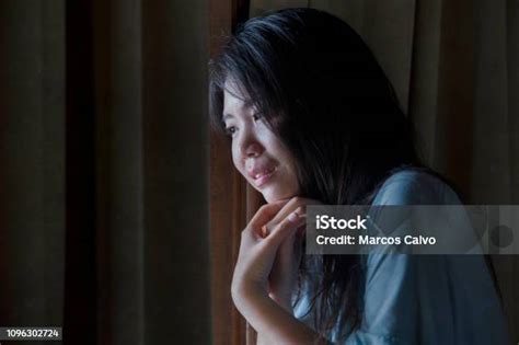 극적인 실내 여자의 초상화 젊은 슬 프 고 우울 아시아 일본 울고 우울증과 가정에서 어두운 빛에 불안을 겪고 절망 실의 커튼