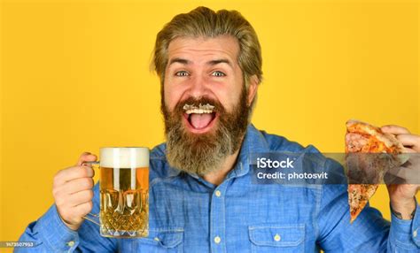 패스트 푸드 맥주와 피자를 가진 행복한 수염 난 남자 이탈리아 음식 이탈리아가 여기에 있습니다 술집에서 맥주를 마시고 피자를 먹는 남자 건배 맥주와 피자 한 잔 Tv에서