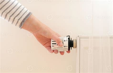 Woman Regulates Temperature At Home With The Heating Thermostat To Save Energy Close Up With