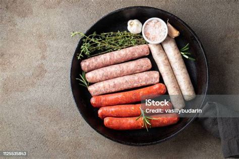백 리 향 로즈마리와 마늘 무 쇠에 모듬된 신선한 생 소시지는 어두운 콘크리트 테이블에 이동합니다 복사 공간 최고 볼 수 있습니다 평면 배치 건강한 식생활에 대한 스톡 사진