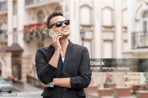 야외 레저 젊은 남자와 선글라스 에 서 서 도시 거리 응답 전화 전화 찾고 찾고 미소 꿈 갈색 머리에 대한 스톡 사진 및 기타 이미지 갈색 머리 기업가 남성 Istock