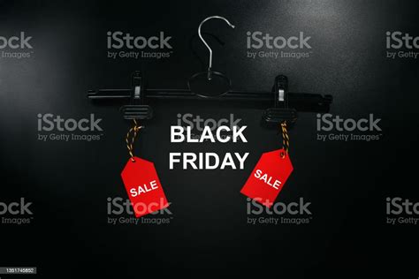 블랙 프라이데이 세일 컨셉 검은 색 배경에 빨간색 빈 태그가있는 검은 색 옷걸이 상단 보기 평평한 평신도 복사 공간 클로즈업 블랙 프라이데이 축하 배너 컨셉 레터링 가격에