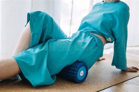 Woman Rolling Hips On A Blue Foam Roller On Cork Mat At Home Myofascial Release Body Awareness