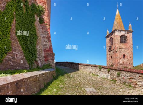 Narrow Paved Street Between Medieval Brick Wall Covered With Green Ivy
