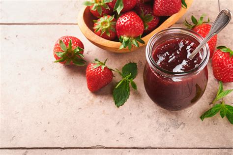 딸기 잼 오래된 금이 간 타일 테이블 배경에 신선한 딸기 접시가있는 유리 병에 딸기 잼 클로즈업 수제 딸기 과일 잼 복사 공간이 있는 위쪽 보기입니다 0명에 대한 스톡 사진