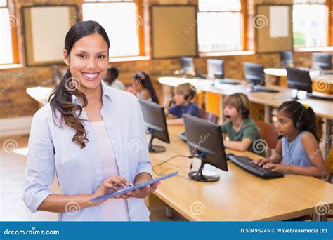 Teacher Using Tablet Computer During A Primary School Class Royalty