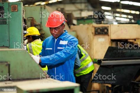 공장에서 기계에 종사하는 흑인 남성 엔지니어 품질 관리 기계를 검사하는 흑인 엔지니어 공장 기계의 서비스 및 유지 보수 미국 아프리카 사람들 20 24세에 대한 스톡 사진