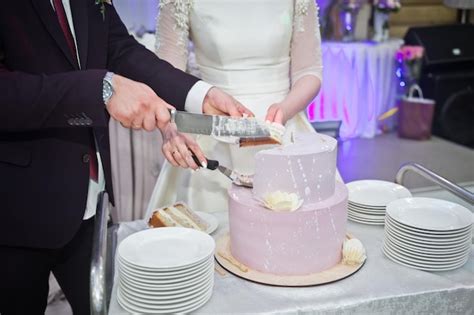 Premium Photo The Process Of Cutting The Wedding Cake At The